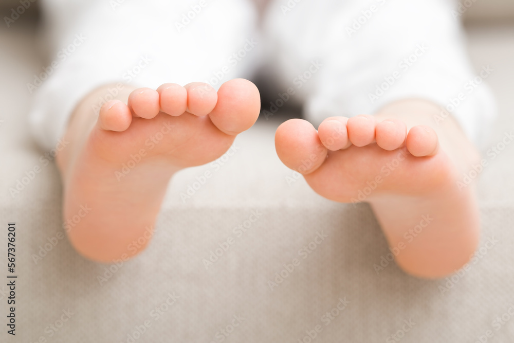 Little child sitting and relaxing on sofa at home room. Barefoot ...