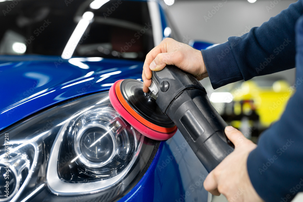 Professional detailing a car in car studio, hands with orbital polisher ...