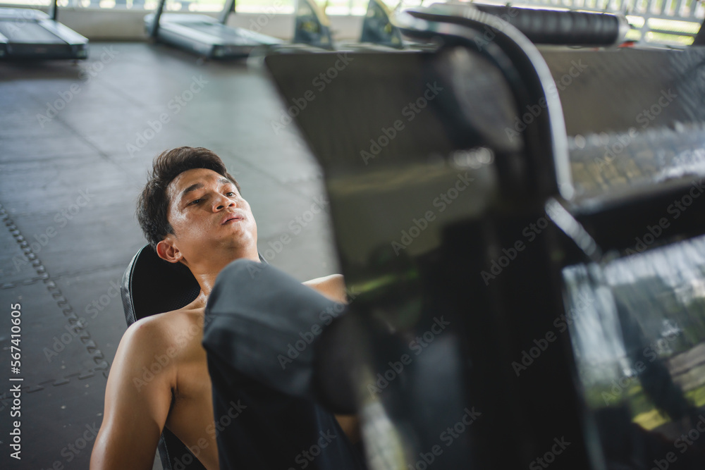 Asian men athletes doing leg press exercises with machines to ...