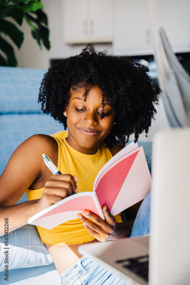 Content black woman taking notes in notepad Stock Photo | Adobe Stock