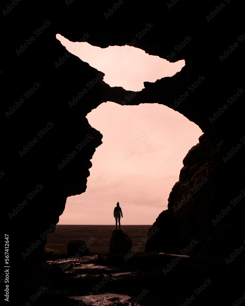 Girl stands on a rock in a famous Yoda cave (Gígjagjá) with beautiful ...