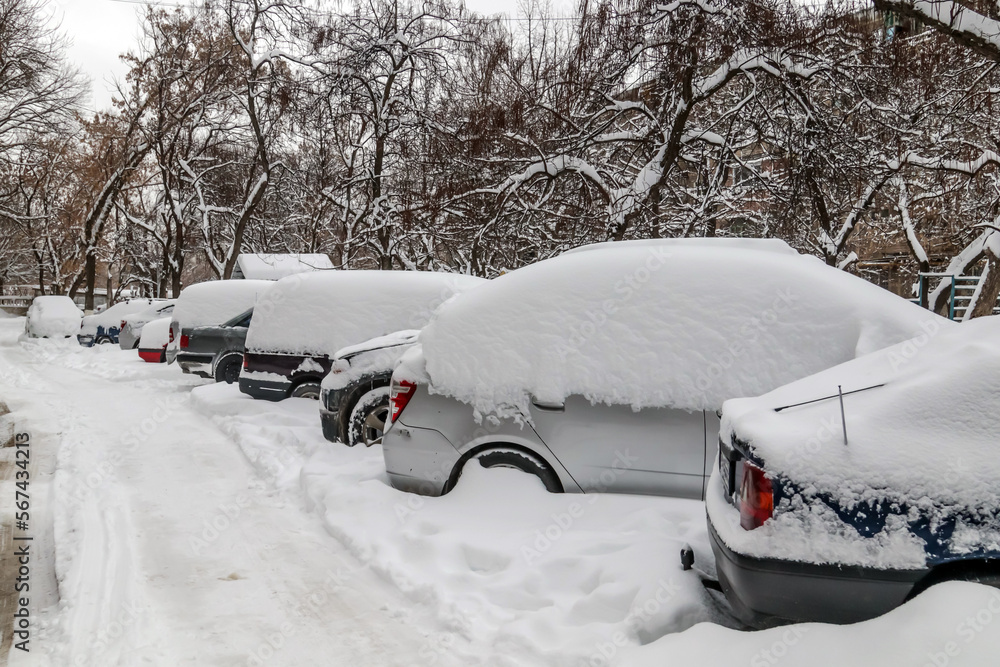 Snow on cars in the morning. Winter season and icy cars on the road ...