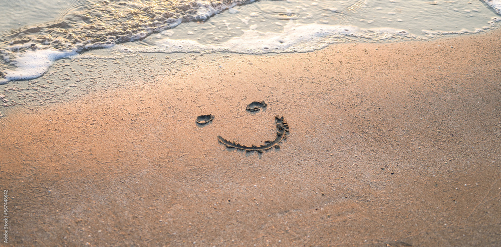 Smiley emoticon on beach sand Stock Photo | Adobe Stock