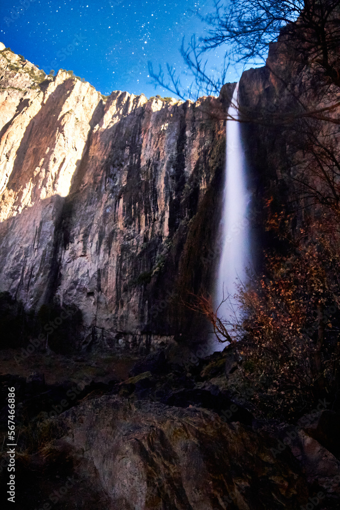 waterfall at moonlight in the night with sky full of stars, high wall ...