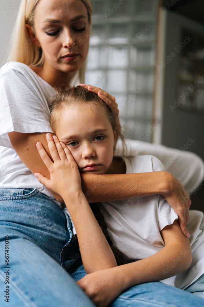Vertical cropped shot of loving caring mother comforting offended upset ...