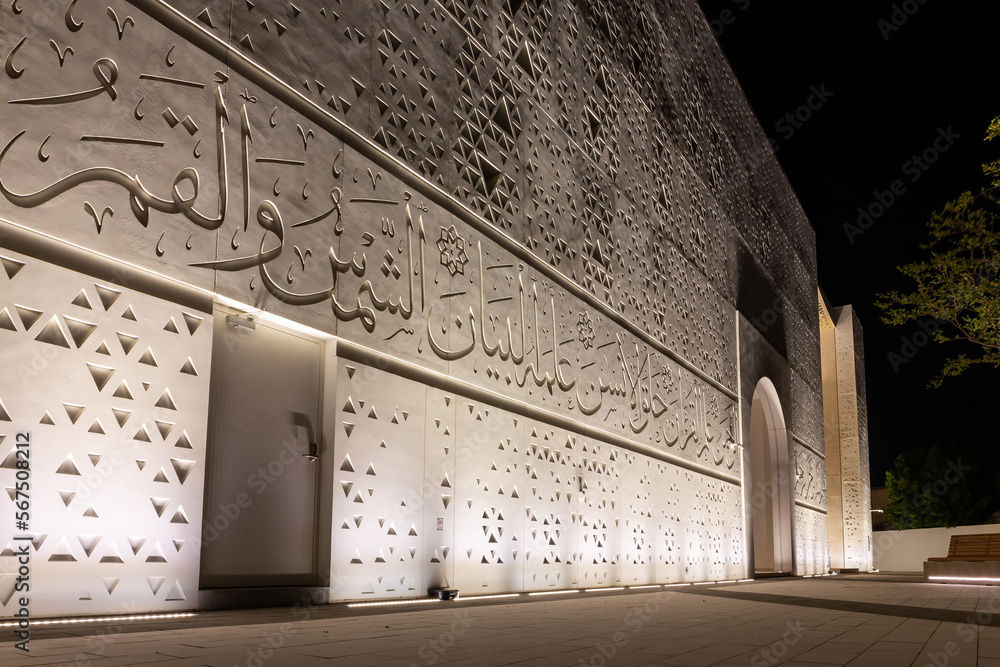Illuminated facade of white Mosque of Light in Dubai, with Quran verses ...