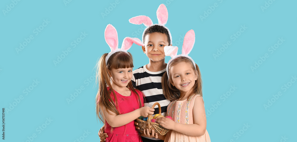 Little children with Easter eggs and bunny ears on light blue ...