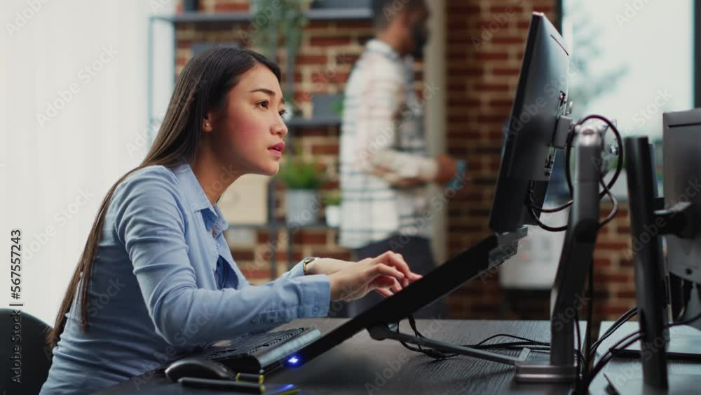 Asian female engineer using touchscreen display to create game ...