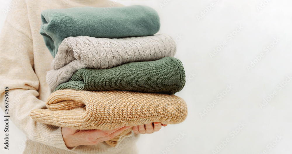 Foto de Woman's hand holding a stack of clothes. Clothes Donation ...