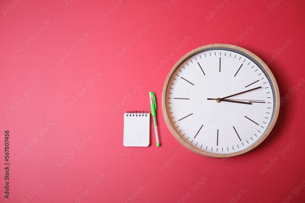Poster Reloj aislado sobre fondo magenta con libreta y bolígrafo ...