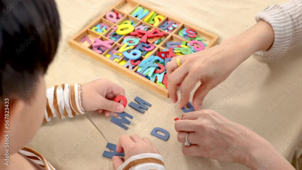 Asian happy single mother and son playing alphabet games with plastic ...