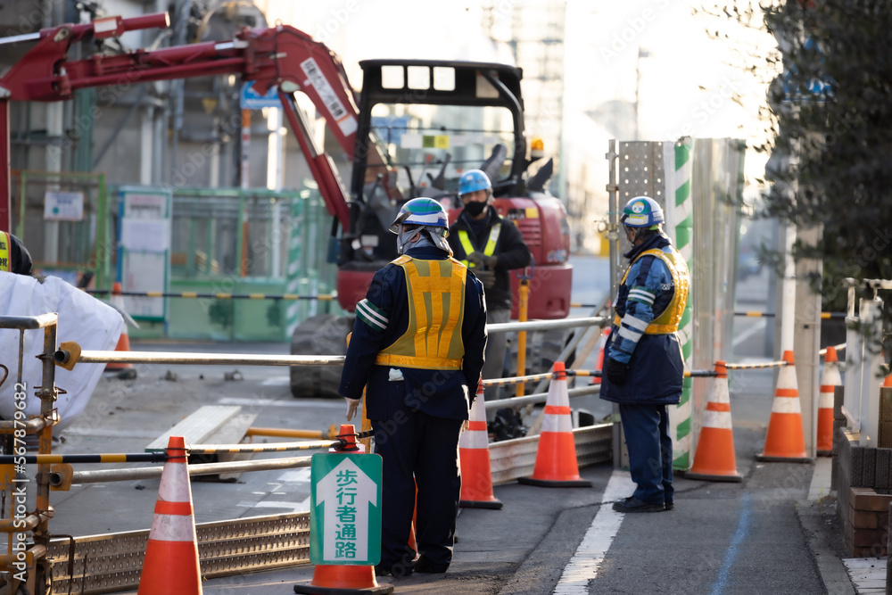 Photo 工事現場の歩行者を誘導する黄色い反射ベストを着た誘導員, captainT | Posters, tableaux et ...