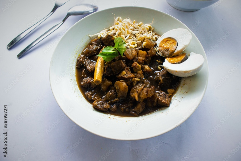 Rawon or Nasi Rawon/Rawon Rice is traditional Indonesian beef black soup served with sprouts ...