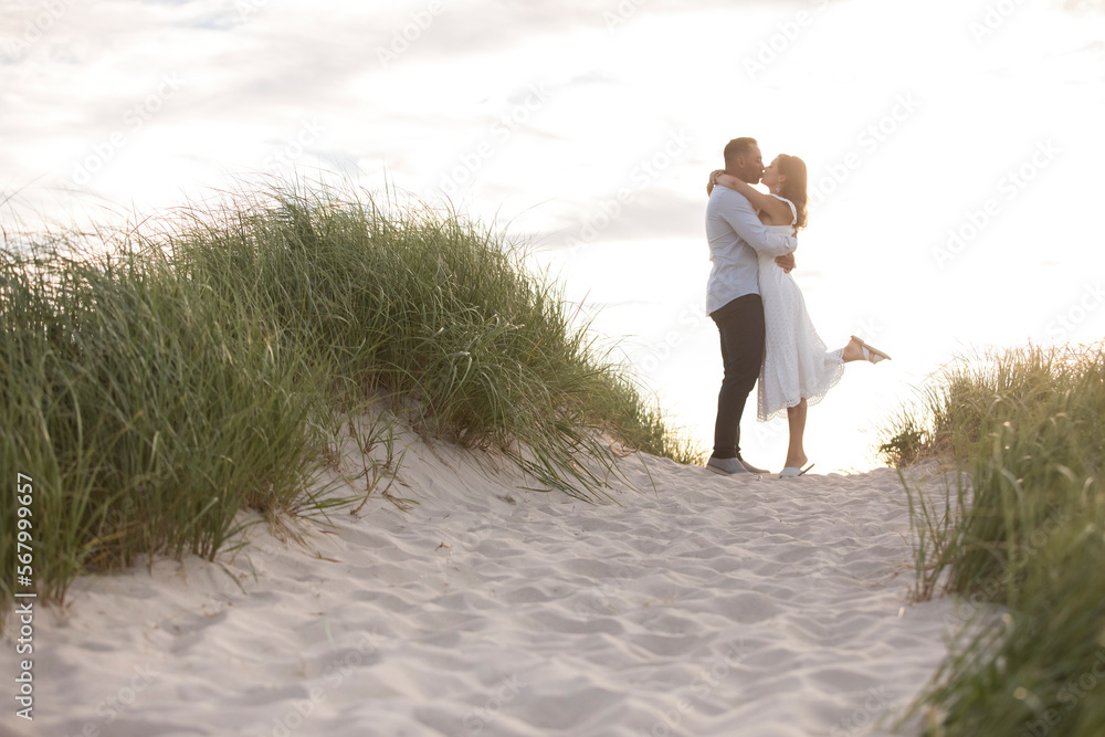 romantic couple kissing at beach from a distance Stock Photo | Adobe Stock