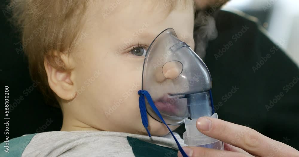 Portrait of a child with an inhaler on his face, the baby is given ...