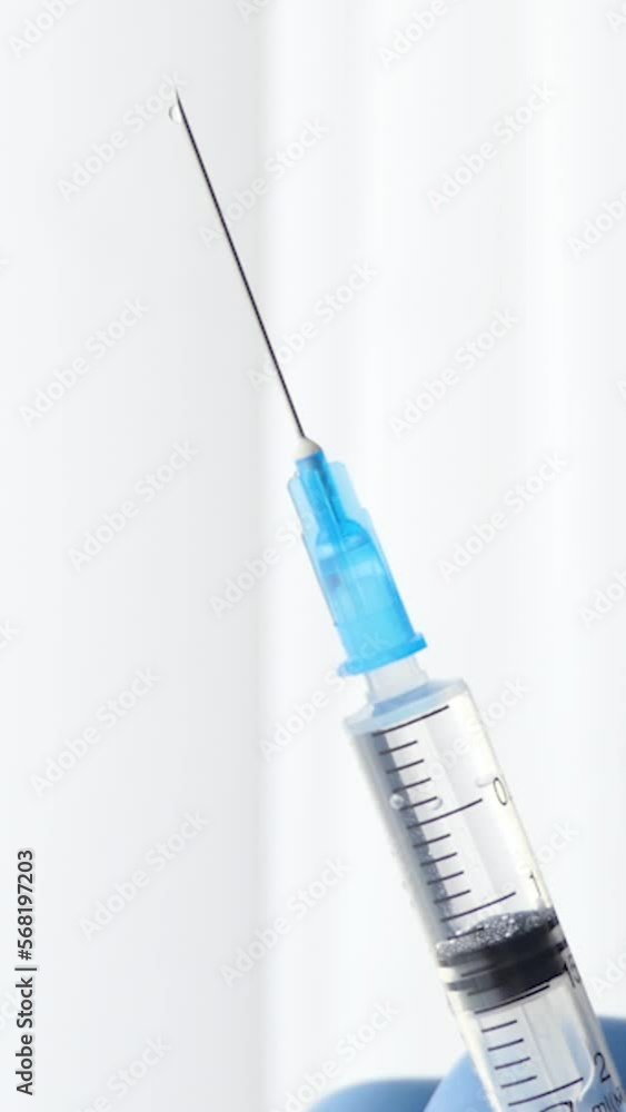Vertical Screen: Close-up of an injection liquid in a syringe on a ...