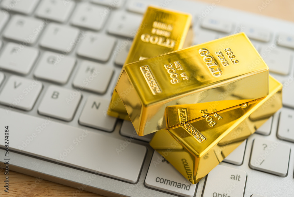 Gold bars on white keyboard computer background. Gold commodity trading ...