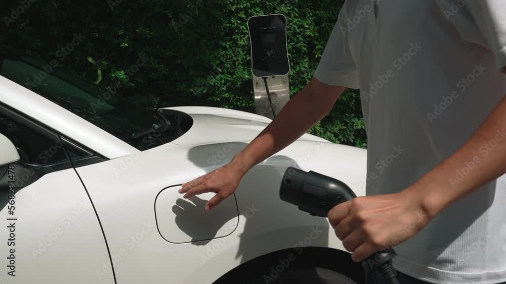 Progressive man install power cable plug to his electric vehicle, EV ...