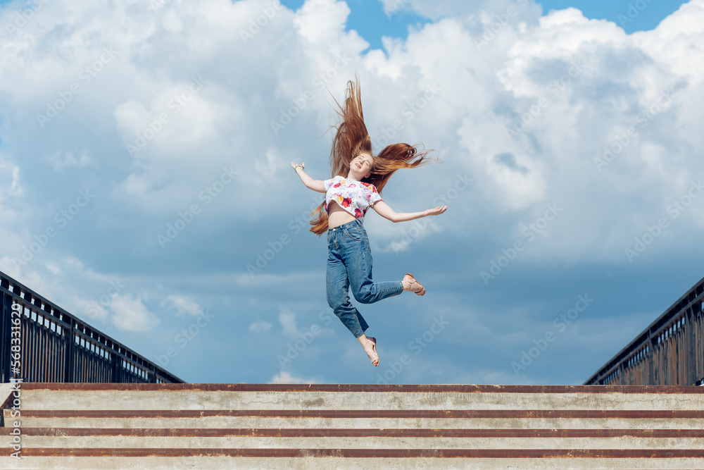 Young teen girl jumping up on the blue cloudy sky background Stock ...