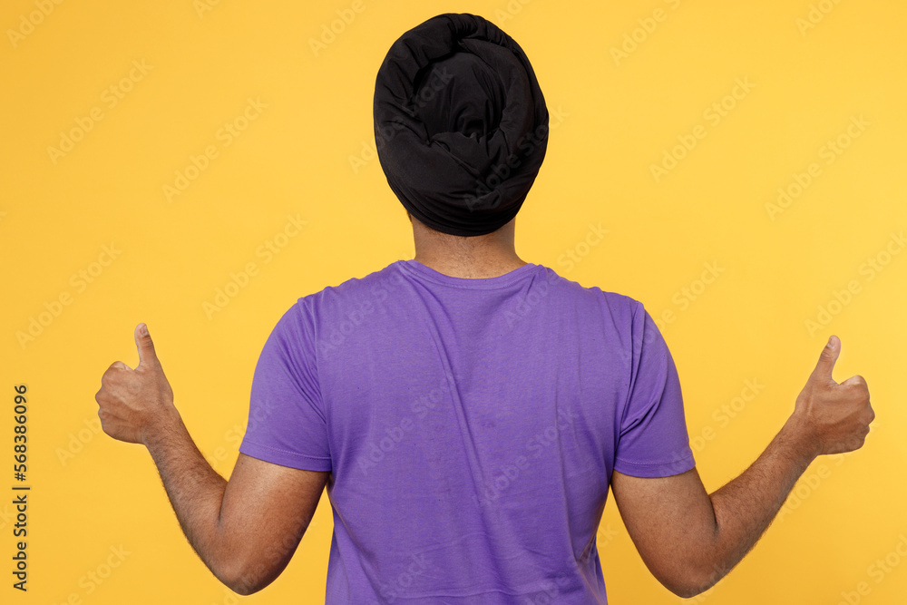 Back view devotee Sikh Indian man ties his traditional turban dastar ...