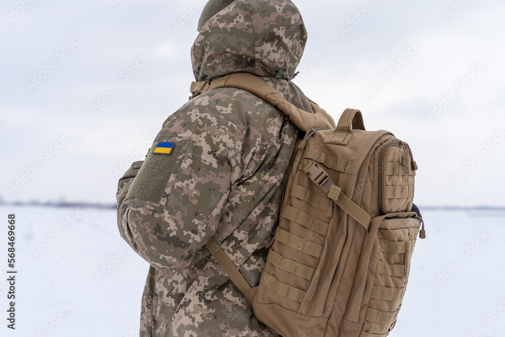 Ukrainian military man in winter uniform with tactical backpack and ...