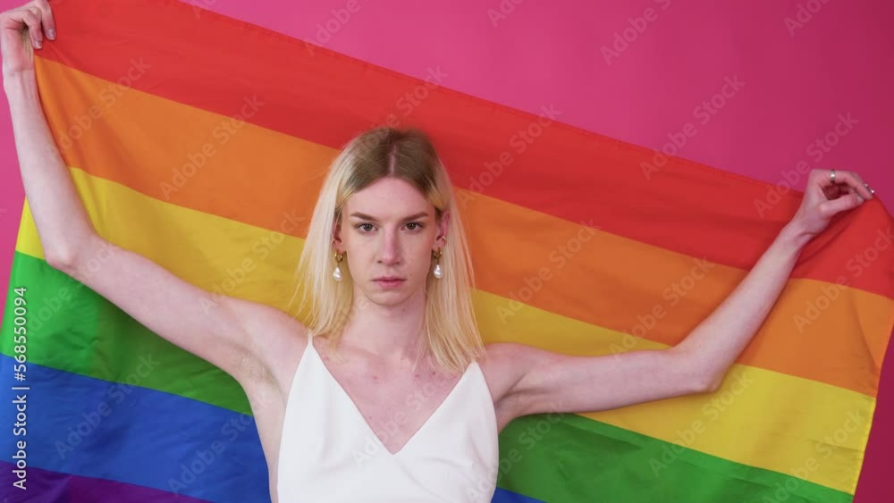 Gender fluid gay man with pride lgbt flag against pink background Stock ...