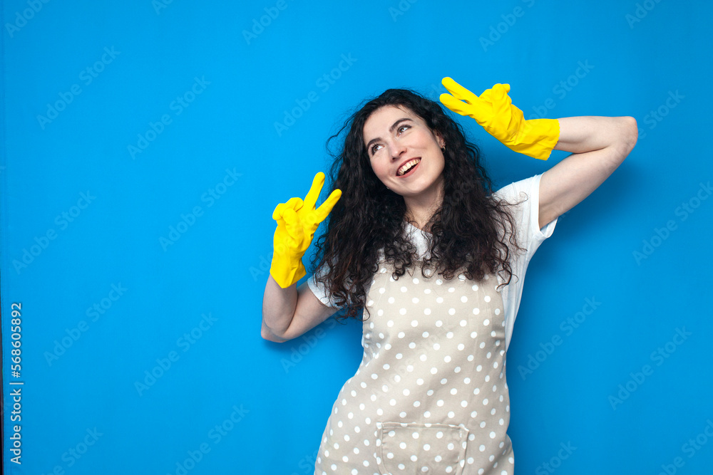 young girl cleaner in uniform and gloves for cleaning shows a gesture ...