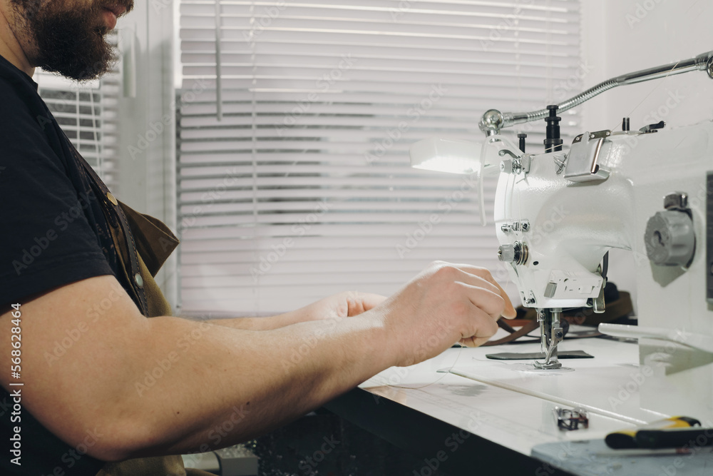 Tailor sewing at workplace. Man hands sewing on machine at his studio ...
