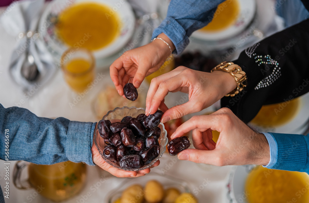 Happy Muslim family having iftar dinner to break fasting during Ramadan ...