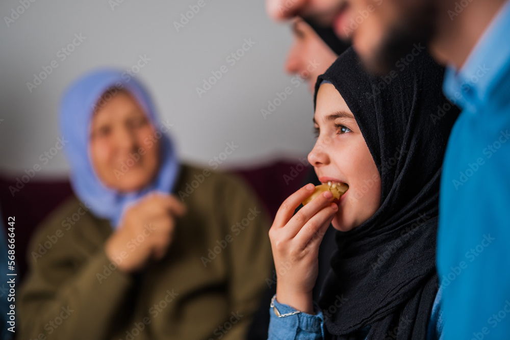 Happy Muslim family having iftar dinner during Ramadan a smiling child ...