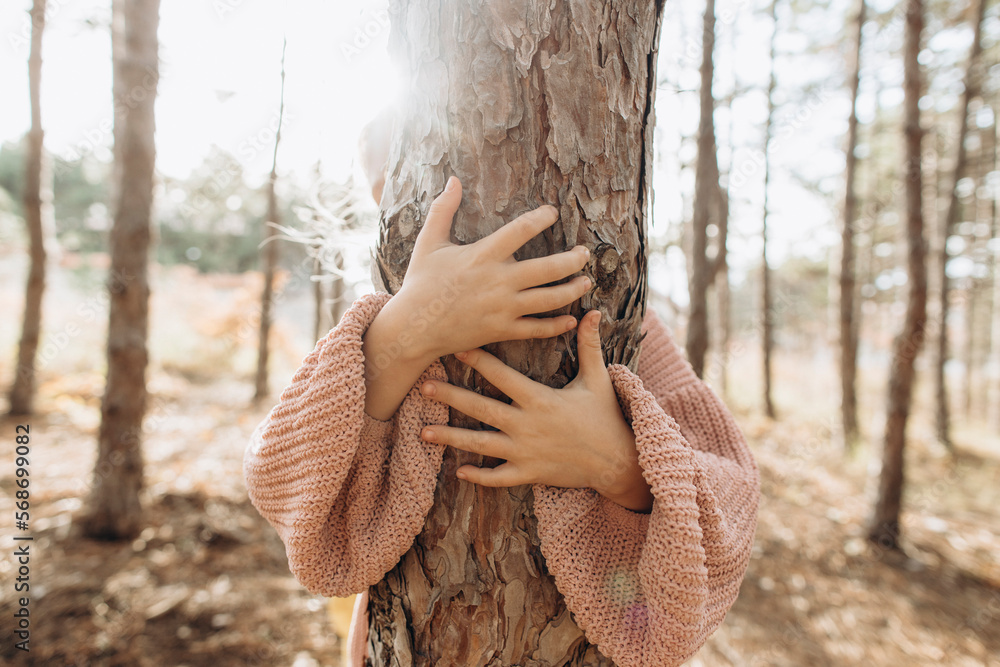 Girl hugging tree trunk in forest Stock Photo | Adobe Stock