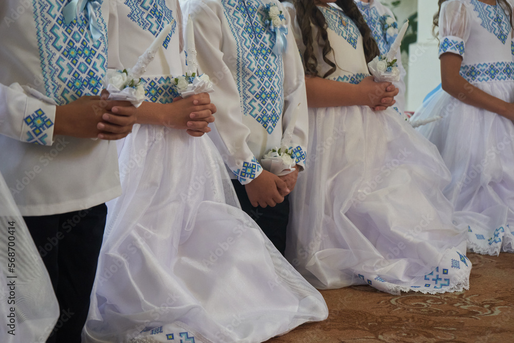 a child in white clothes for the first communion,a group of children on ...