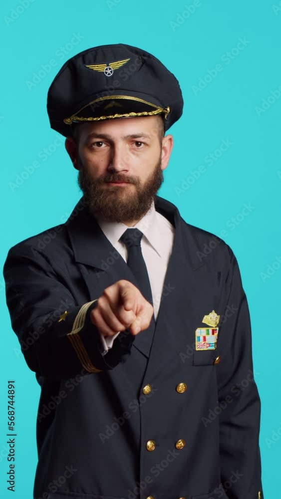 Vertical video: Airplane pilot in uniform pointing at camera and ...