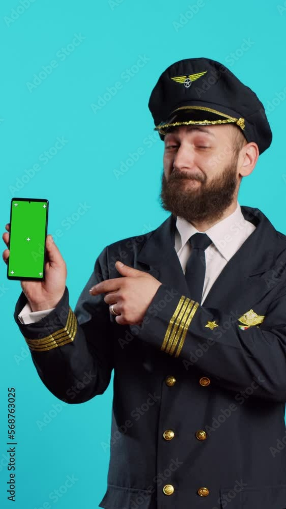 Vertical video: Positive aircrew captain showing phone with greenscreen ...