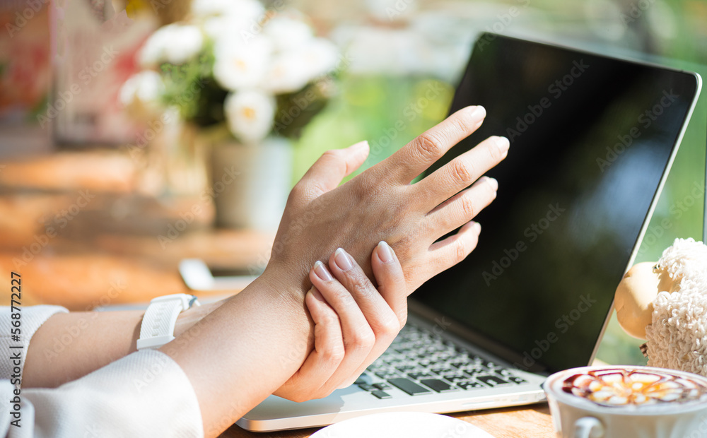 Closeup woman holding her wrist pain from using computer. Office ...