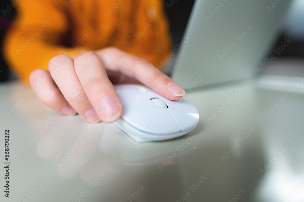 From above, close-up photo of a hand with a wireless white computer ...