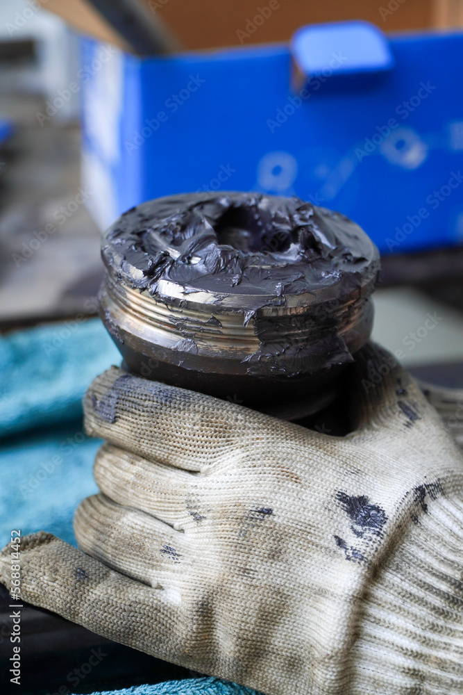 Asian mechanic changing axle and grease CV in front wheel drive car in garage,Macpherson ...