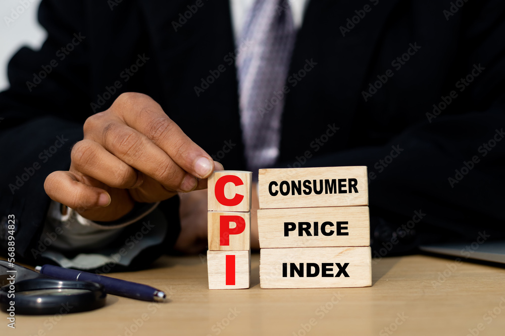 CPI, consumer price index symbol. hand holding wooden block with words ...