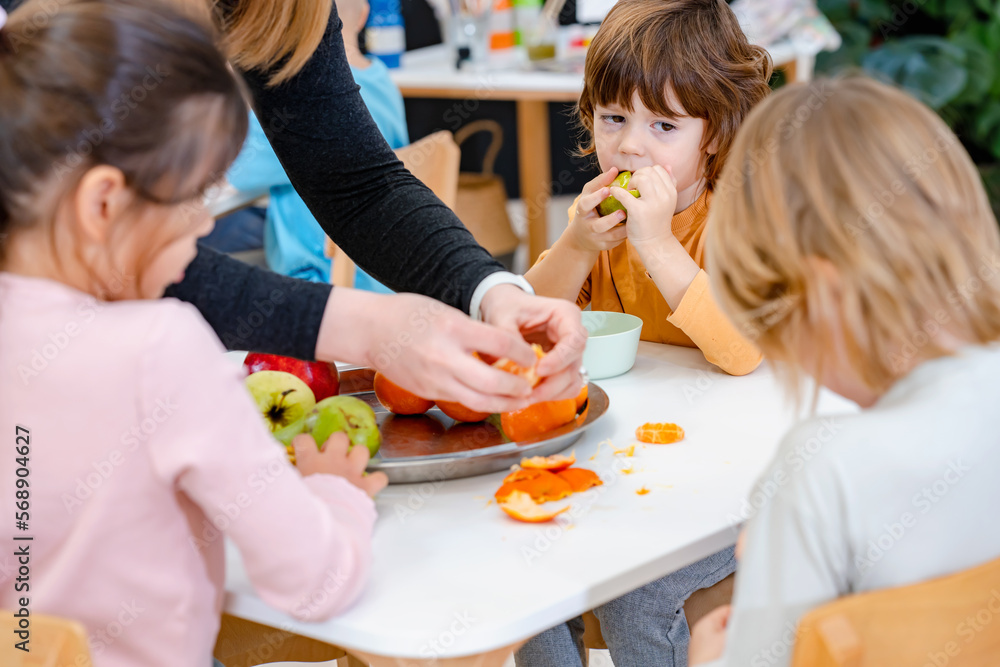 Children eating a fruit snack in a kindergarten Stock Photo | Adobe Stock