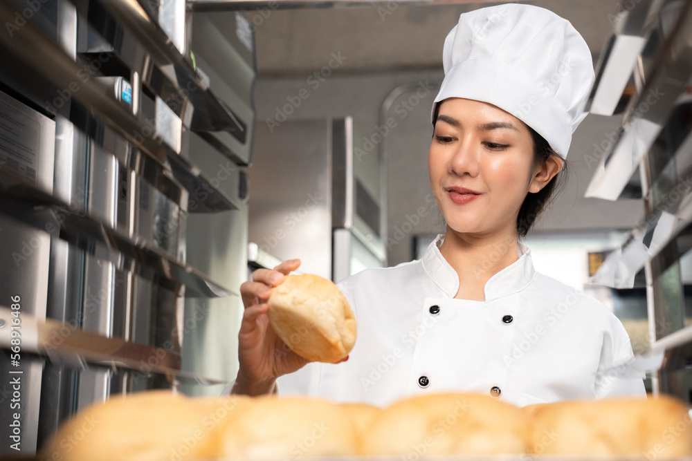 Selective focus, front view of a beautiful Asian female baker in chef ...