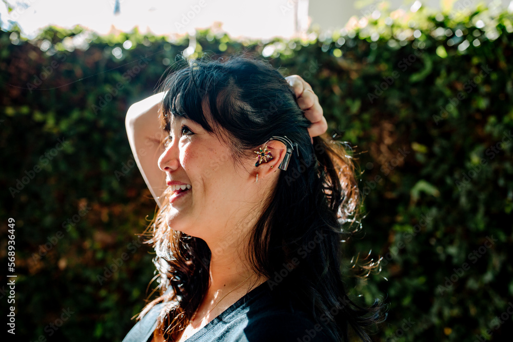 Smiling asian woman wearing a cochlear implant Stock Photo | Adobe Stock