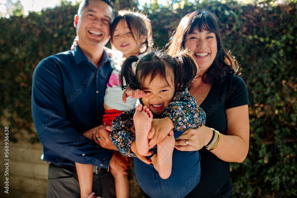 Smiling family with toddlers hugging and laughing together Stock Photo ...