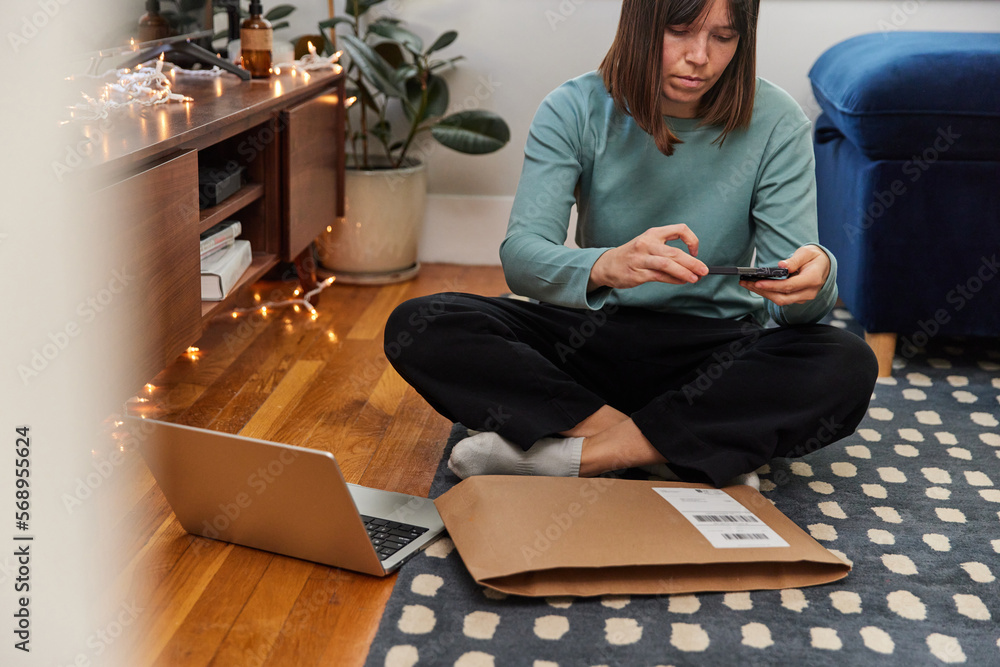 Woman scans parcel code at home Stock Photo | Adobe Stock