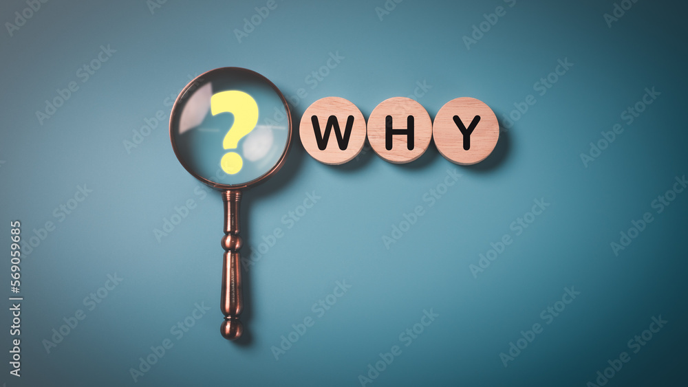 Question mark on magnifying glass and wooden block on a blue background ...