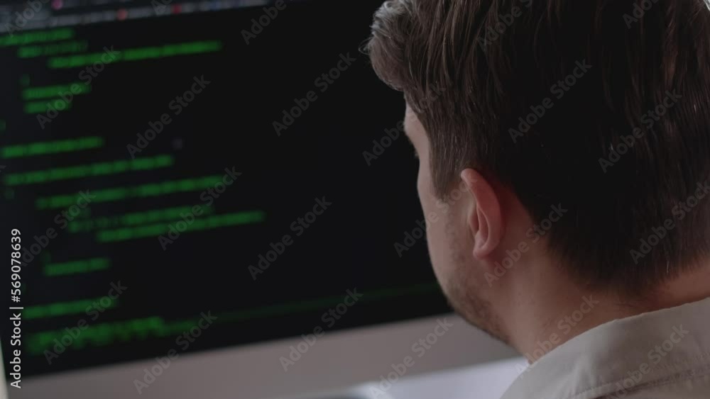 Programmer typing code on a desktop monitor, web security in bank ...