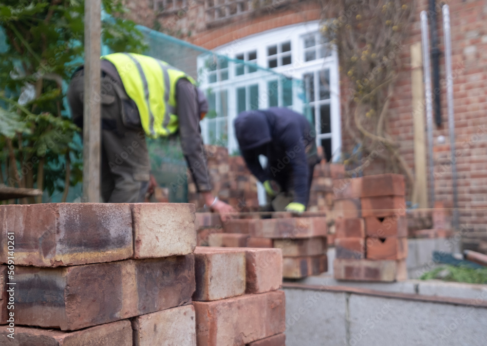 Two construction workers laying bricks as part of a renovation of an ...