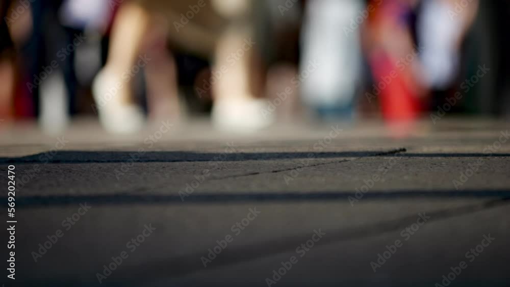 Legs of a crowd of people walking down the street, close-up of people's ...