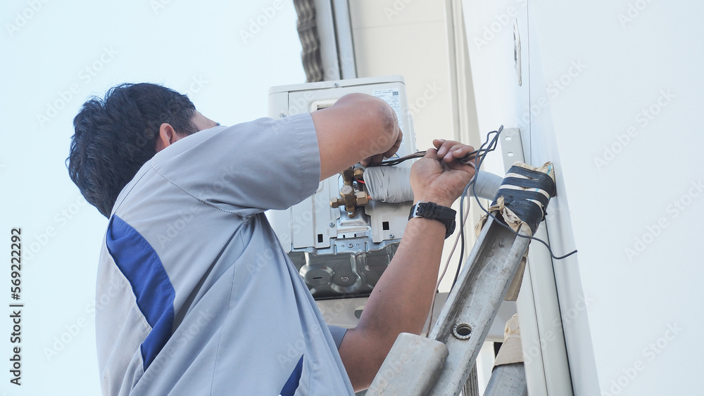 Foto de An air conditioner technician is installing an air conditioner ...