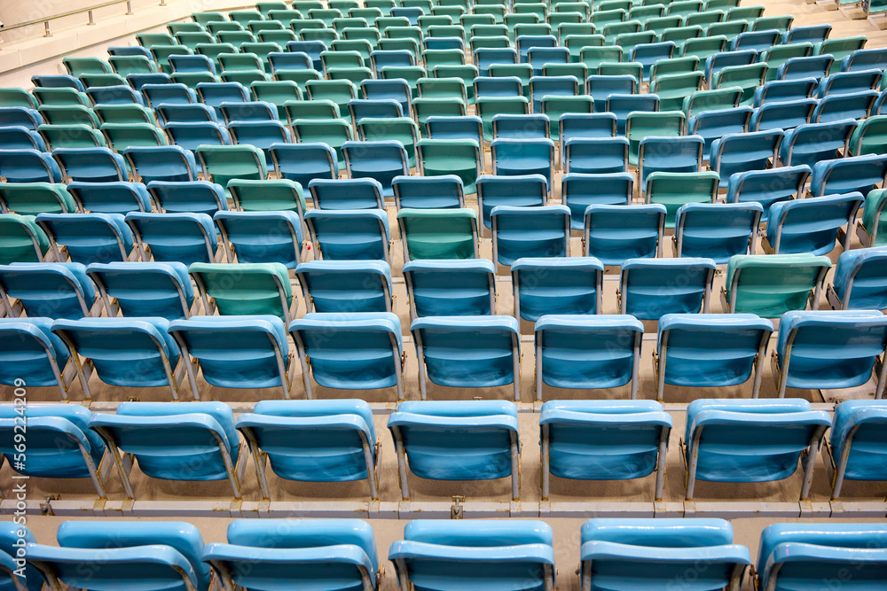 Empty seats in the stadium for fans with blue chairs. Stands at the ...