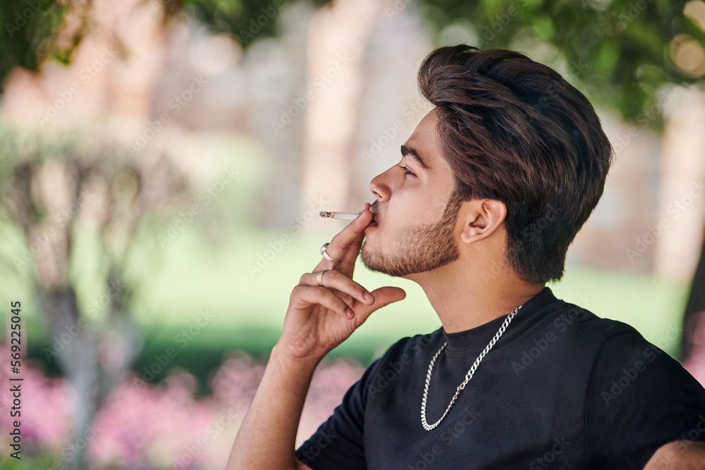 Young indian man smoker portrait in black t shirt and silver neck chain ...